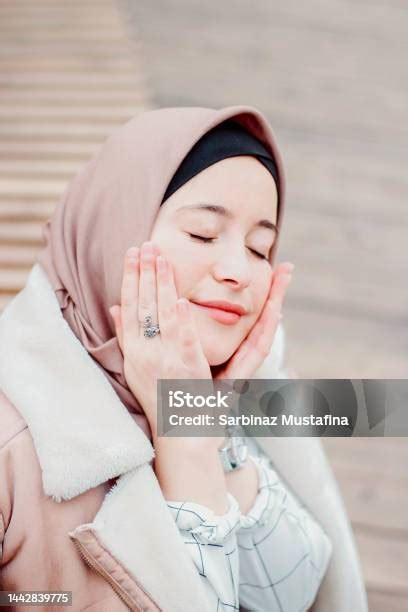 베이지 색 코트와 머리 스카프를 입은 무슬림 여성 공원에있는 세련된 무슬림 여성 벤치에 앉아있는 소녀 20 24세에 대한 스톡 사진 및 기타 이미지 Istock