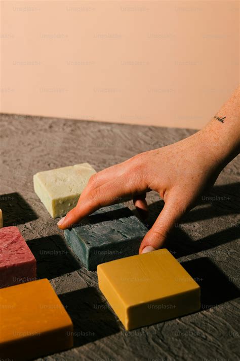 비누 블록에 손을 뻗는 사람의 손 사진 Unsplash의 네거티브 공간 이미지