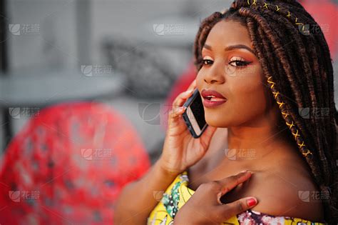 可爱的小个子非裔美国女孩，梳着发辫，穿着黄色的连衣裙