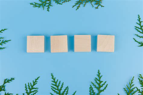 네 개의 나무 블록은 파란색 배경에 사이프러스 가지를 휘파람 새해 크리스마스의 개념 0명에 대한 스톡 사진 및 기타 이미지