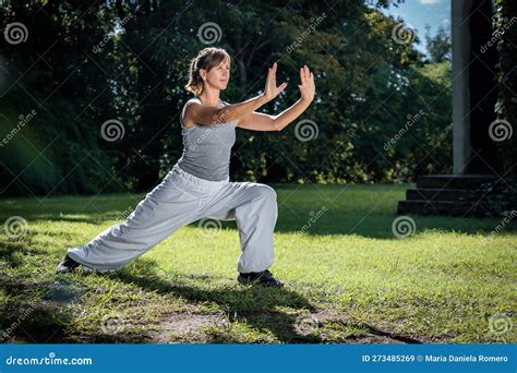 Side Portrait Of A Woman Doing Tai Chi Exercise In Natural Environment