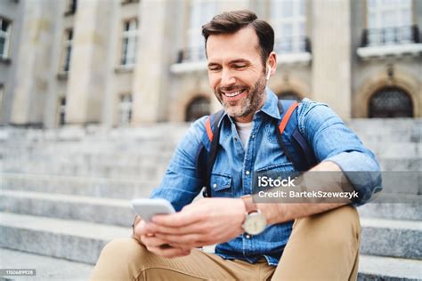 남자는 도시에서 밖으로 계단에 앉아 귀에 무선 헤드폰 전화를 사용 하 여 배낭에 대한 스톡 사진 및 기타 이미지 배낭 전화 헤드폰 Istock