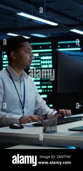 Vertical Video System Administrator In Wheelchair Overseeing Data Center Using Computer