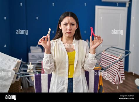 Young Latin Woman Holding Clothespins Hanging Clothes On Clothesline Young Latin Woman Holding Clothespins Hanging Clothes On Clothesline