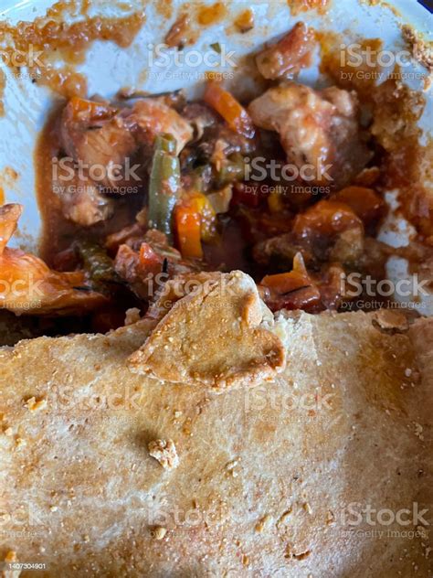 에나멜의 전체 프레임 이미지 오븐 방지 서빙 요리 누락 된 부분이있는 수제 치킨 파이 파삭 파삭 한 패스트리 뚜껑 다진 당근과 양파가 들어간 풍부한 육즙에 닭고기 덩어리