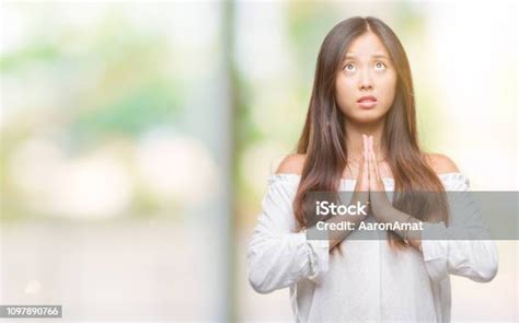 구걸 하 고 손으로 얼굴 매우 감정적이 고 걱정에 희망 식 함께 기도 격리 된 배경 위에 젊은 아시아 여자 용 서에 대 한 요구 종교 개념입니다 애원하기에 대한 스톡 사진