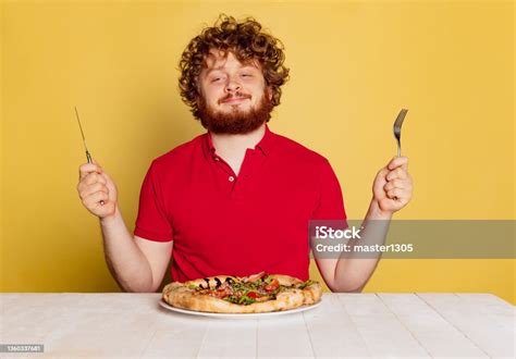 노란 스튜디오 배경에서 고립된 맛있는 이탈리아 피자를 먹을 준비를 하고 있는 붉은 수염을 기운 남자의 초상화 25 29세에 대한 스톡 사진 및 기타 이미지 Istock