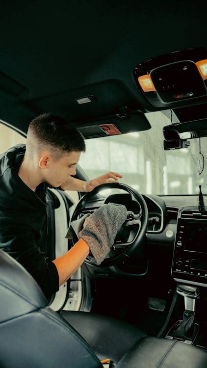 정밀하게 자동차 내부를 청소하는 남자 · 무료 스톡 사진