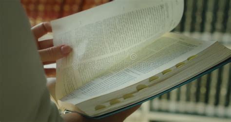 woman self taught reading a book in library female hand runs a finger