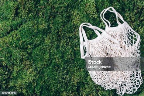 녹색 잔디 이끼 배경에 재사용 가능한 그물 가방 또는 메쉬 구매자 제로 폐기물 플라스틱 무료 개념 맨 위 보기입니다 친환경 메쉬 구매자 지속 가능한 생태학 유기농 라이프