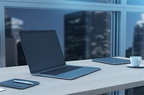 창 배경에서 야간 도시 전망에 노트북과 커피 컵이있는 밝은 나무 테이블에 로고 또는 텍스트를위한 카피 스페이스가있는 빈 어두운 노트북 화면의 원근감보기 3d 렌더링 모의 0