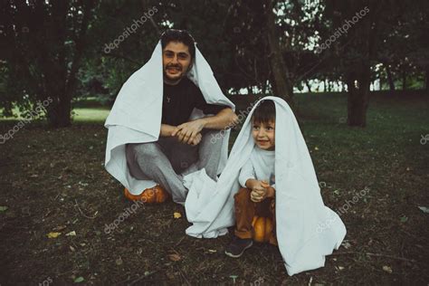 Padre E Hijo Jugando Fantasmas Con Sábanas Blancas En El Jardín Fotos