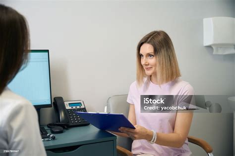 의사 진료 예약에서 설문지를 작성하는 미소 짓는 여성 환자 25 29세에 대한 스톡 사진 및 기타 이미지 25 29세 2명 30 34세 Istock