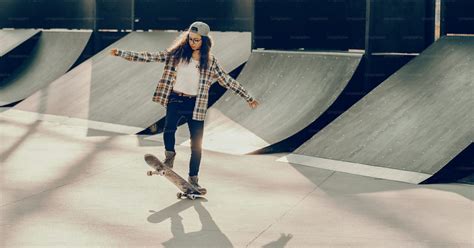 곱슬머리와 모자를 쓴 귀여운 혼혈 십대 소녀가 스케이트 공원에서 스케이트보드를 타고 있다 사진 Unsplash의 스포츠 이미지