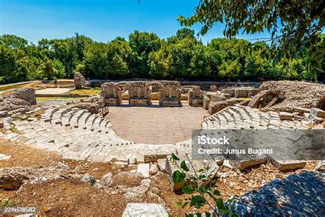 알바니아 부트린트 국립공원에 있는 고대 로마 극장 유적으로 푸른 지중해 삼림 지대 한가운데에 층층이 쌓인 석조 좌석과 나무 무대가 있습니다 0명에 대한 스톡 사진 및 기타