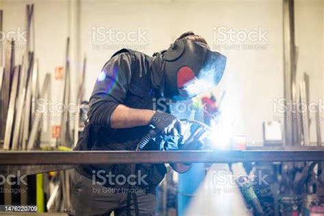 보호 마스크와 작업복을 입고 용접공으로 일하는 남자의 프로필보기는 Migmag 용접기로 작업을 수행합니다 용접 작업 생산 1940 1949 년에 대한 스톡 사진 및 기타