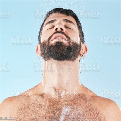 샤워 물 깨끗한 몸매를 가진 남자와 위생 몸단장 스킨케어를 파란색 스튜디오 배경으로 합니다 얼굴 청소 물방울과 얼굴 자연 치료 및 미용 모형이있는 모델 가꿔주기에 대한 스톡