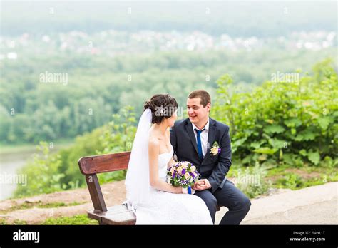 Attractive Bride And Groom Sitting On A Bench Stock Photo Alamy