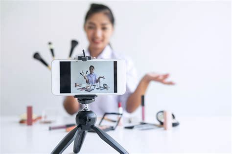 메이크업 브러쉬를 가진 여성 블로거 흰색 배경 위에 모바일 화면에서 볼 수 있는 미용 제품 메이크업 화장품에 대한 스톡 사진 및 기타 이미지 Istock