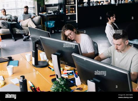 female and male programmers coding on computers while working in