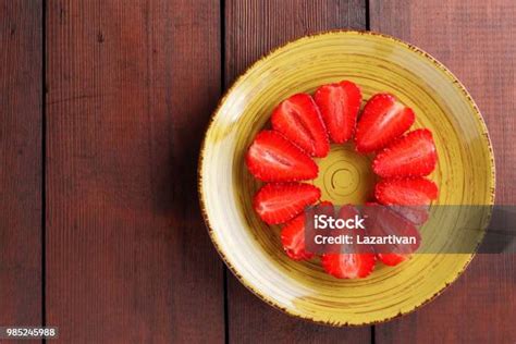 딸기 나무 보드 원 노란색 접시 아침 식사 채식 음식에 붉은 열매의 형태에 빨간 딸기의 반쪽에 복사 공간 디자이너 크리에이 티브에 대 한 빈 건강한 생활방식에 대한 스톡