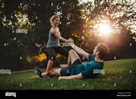 Shot Of Young Woman Helping Man To Get Up From Ground Healthy Young