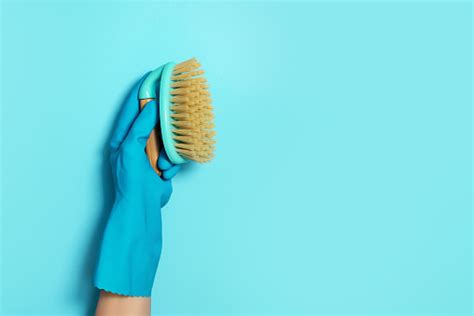 파란색 배경에 브러시를 들고 장갑에 손을 공간을 복사합니다 청소 집 청소 화장실 개념 청소 서비스 개념 가정용 화학 적 세척 제품 브러시 및 용품 가사 집안일에 대한 스톡