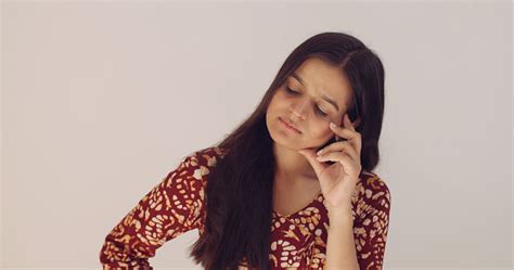 젊은 인도 여성은 흰 벽의 배경에 걱정스러워 보이는 그녀의 머리에 손을 얹고 있다 걱정하는에 대한 스톡 사진 및 기타 이미지