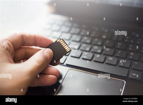 Memory Card In Hand Laptop Keyboard Flash Drive Information Data Base Technology Stock