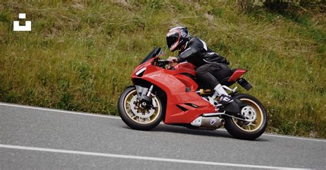 빨간 오토바이를 타고 구불구불한 도로를 달리는 남자 사진 Unsplash의 무료 자전거 라이더 이미지