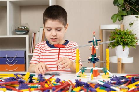 Premium Photo A Little Boy Plays With A Constructor Creating Figures