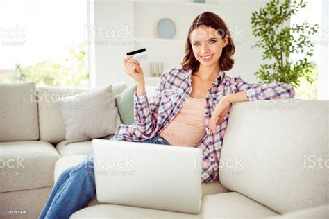 클로즈업 사진 아름 다운 그녀 그녀의 레이디 밥 노트북 플라스틱 무선 신용 카드 손 팔 추천 온라인 쇼핑 착용 체크 무늬 셔츠 청바지 데님 앉아 디반 하우스 다락방 거실