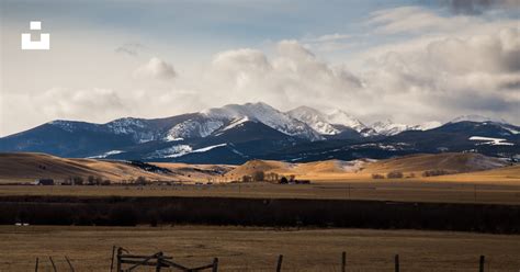 낮에는 흰 구름 아래 산 근처의 갈색 들판 사진 Unsplash의 무료 보즈 먼 이미지
