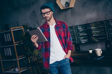 웃고있는 영리한 프리랜서 입고 있다 모자 안경 쇼핑 전자 카드 전자 리더 현대 개그뎃 실내 직장 워크 스테이션 로프트의 사진