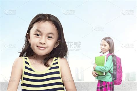 亚洲小女孩拿着书和背包去学校