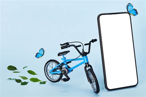 창조적 인 에코 배달 개념 복사 공간 파란색 배경에 자전거와 나비와 스마트 폰 지속 가능한 택배 서비스 두발자전거에 대한 스톡