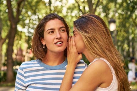 Dos Amigos Comparten Un Secreto Ntimo En Un Parque Foto Premium