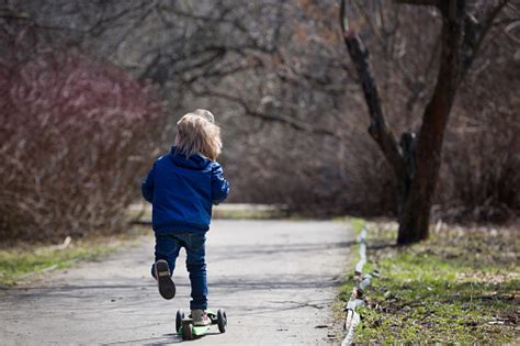 귀여운 아이 소년 그의 스쿠터를 타고 화창한 날에 공원에서 재미 야외에서 아이 들과 함께 활동 스쿠터에 아이 라이프 스타일과 활동적인 레저 컨셉 가을에 대한 스톡 사진 및