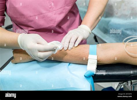 The Doctor Disinfects The Patients Hand With An Alcohol Solution The Doctor Disinfects The Patients Hand With An Alcohol Solution
