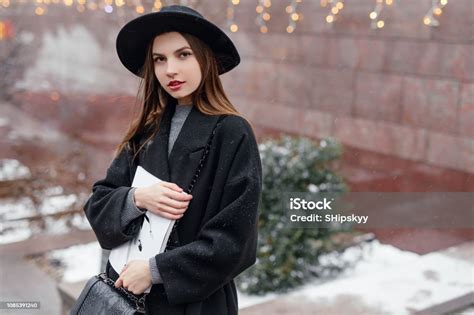 젊은 패션 여자 잡고 그녀의 잡지 도시 거리에 도보 둘러 검은 모자를 착용 하 고 카메라에 미소 공간에 복사 합니다 이미지 아침에 대한 스톡 사진 및 기타 이미지 Istock