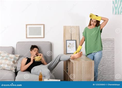 Lazy Husband Lying On Sofa And His Wife Cleaning Stock Image Image Of