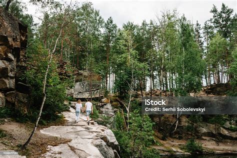 다리 젊은 부부는 돌에가 고 전체 길이 바위의 배경에 뒤에서 남자와 여자의 보기 오래 된 산업 화강암 채 석 장의 풍경입니다 손을 잡고 있는 사람들 2명에 대한 스톡 사진