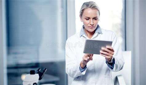 Processing Scientific Data On Her Device A Mature Scientist Using A Digital Tablet While