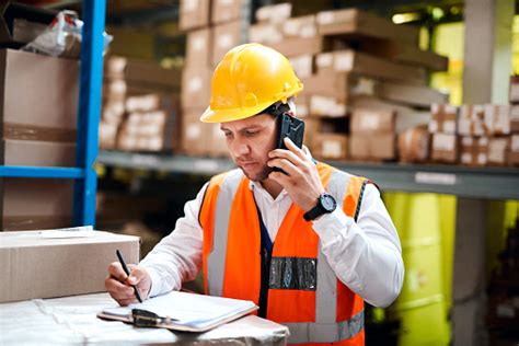 물류 전화 통화 클립보드 및 화물 상자 주문 선적 컨테이너 또는 공급망 배송을 작성하는 사람 통신 유통 컨설팅 및 공장 관리자와 재고 재고 체크리스트 공장 산업 건물에 대한