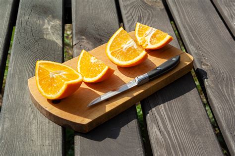 칼로 태양 조명에 나무 갈색 테이블에 도마에 오렌지 과일의 잘라 낸 조각을 식욕을 돋우는 건강한 식사 과일 여름 0명에 대한