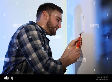 Man Installing Security Alarm System On Light Wall At Home Stock Photo Alamy