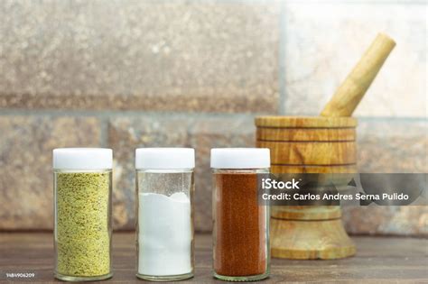 피망 소금 파프리카가 담긴 유리병 3개가 박격포와 벽돌 벽을 배경으로 한 나무 테이블 위에 놓여 있다 0명에 대한 스톡 사진 및 기타 이미지 Istock