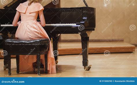 Close Up View Of Cute Teenager Girl Plays Piano In The Concert Hall At