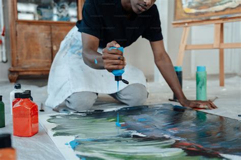 한 남자가 바닥에 그림을 그리고 있다 사진 Unsplash의 예술가 이미지