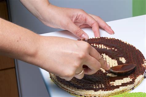 여자는 초콜릿 웨이퍼 케이크와 함께 발 랐 습 와플 삶은 연유와 초콜릿 케이크입니다 요리 과정입니다 웨이퍼 케이크 코코아와 농축 우유 요리 성분 이다 0명에 대한 스톡 사진